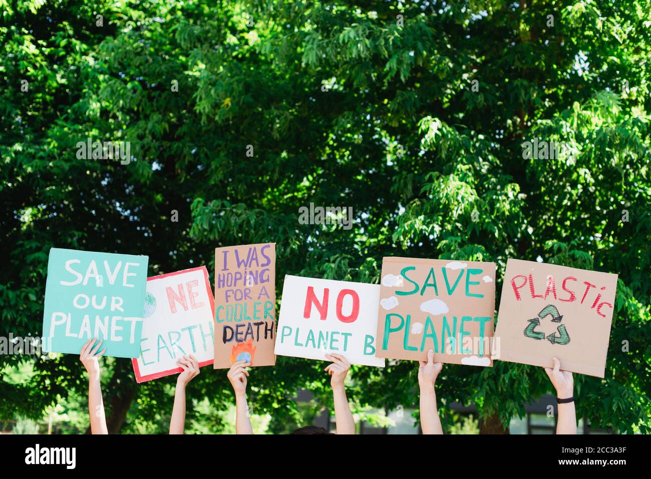 People holding placards with save planet and plastic recycle lettering ...