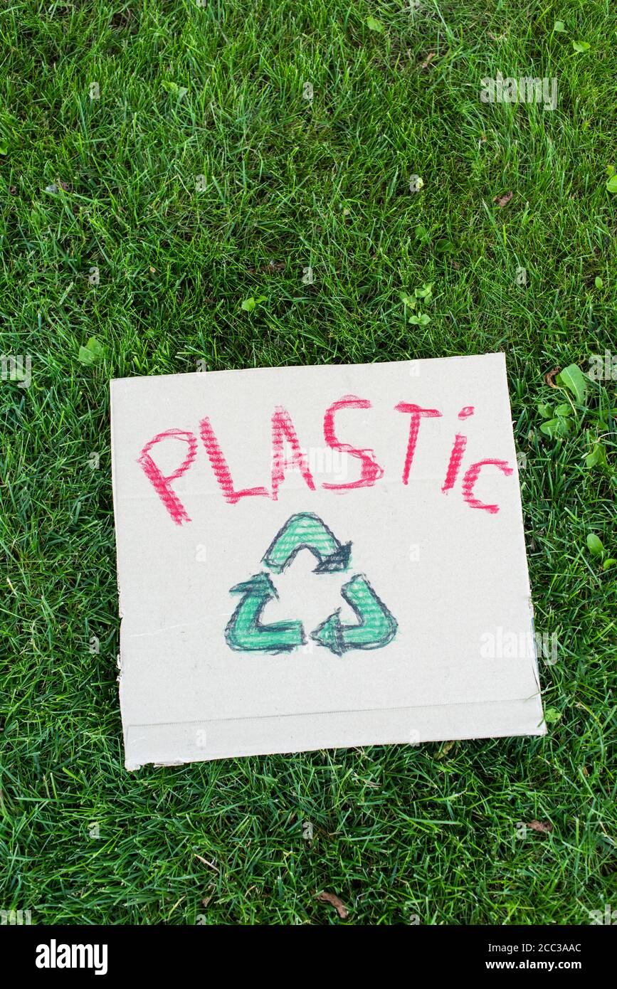 Top view of placard with plastic lettering and recycle sign on grass ...