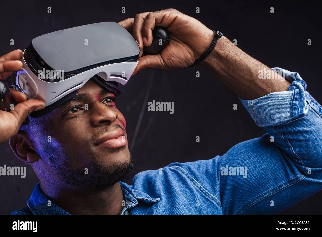 African male architector taking off his virtual reality headset looking ...
