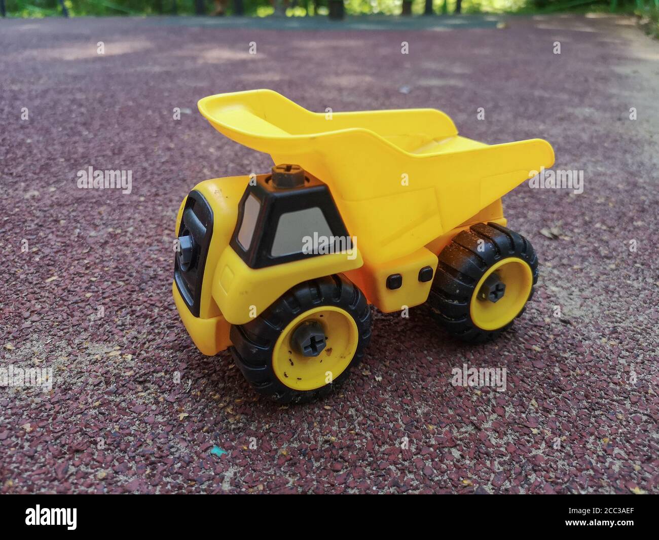 Small toy yellow truck on the rubber cover of the playground Stock ...