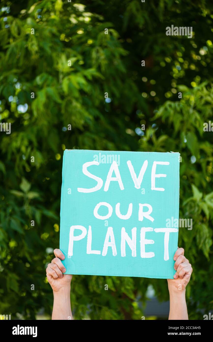 Cropped view of man holding placard with save our planet lettering with ...