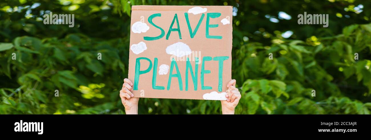 Panoramic shot of man holding placard with save planet lettering with ...