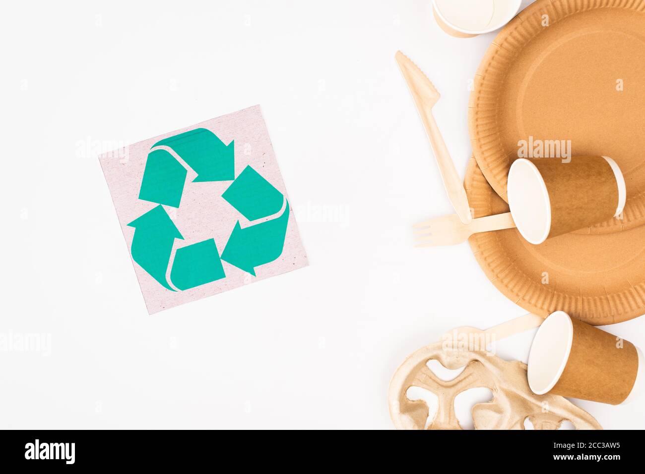 Top view of card with recycle sign and disposable tableware and wooden ...