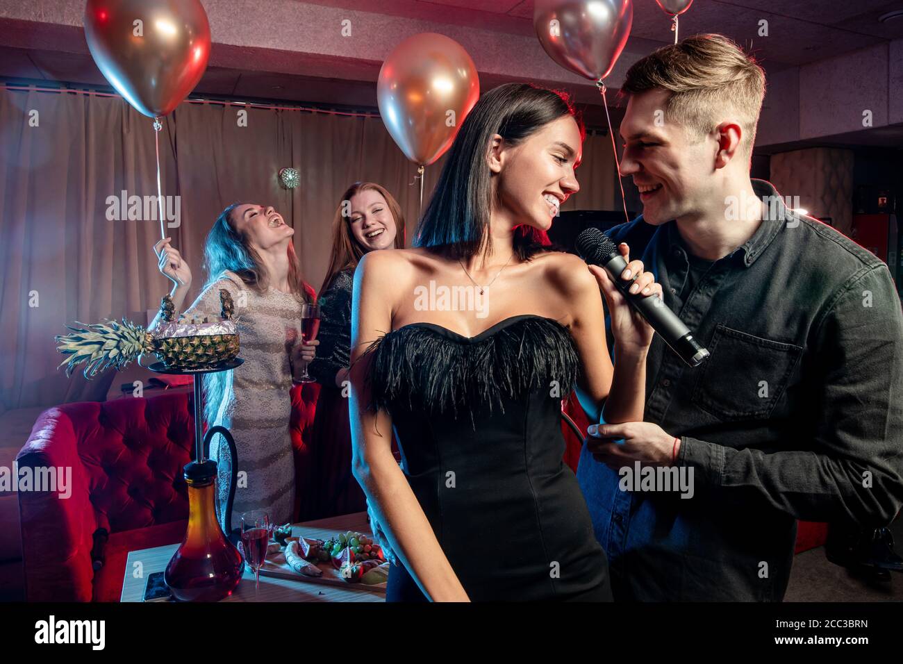 beautiful caucasian couple spend free time, celebrating in karaoke bar ...