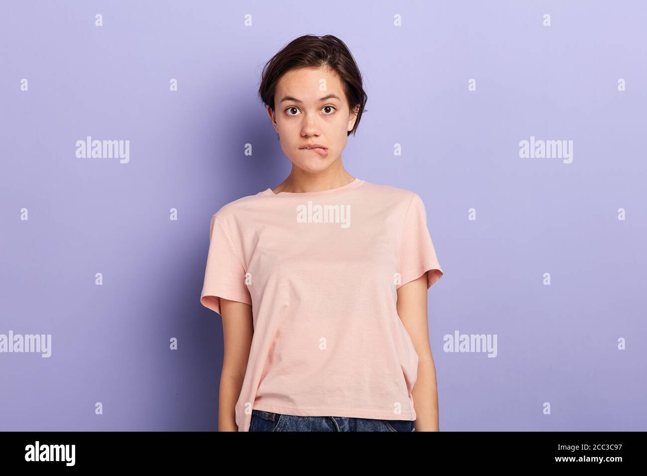 Shy beautiful girl with white t-shirt and jeans having indecisive ...