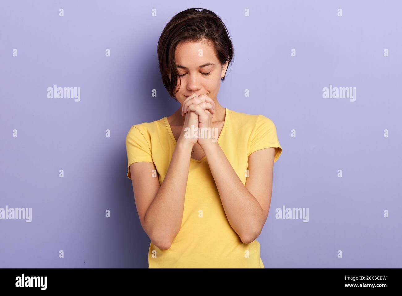 beautiful calm woman praying with closed eyes. Her hands are chained by ...