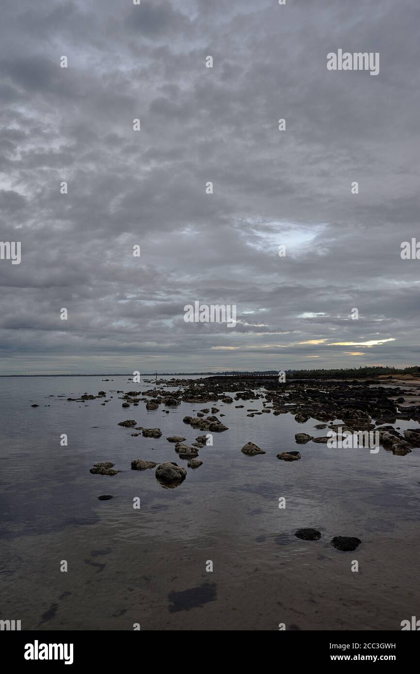 quiet flat seas under a dramatic brooding sky Stock Photo - Alamy
