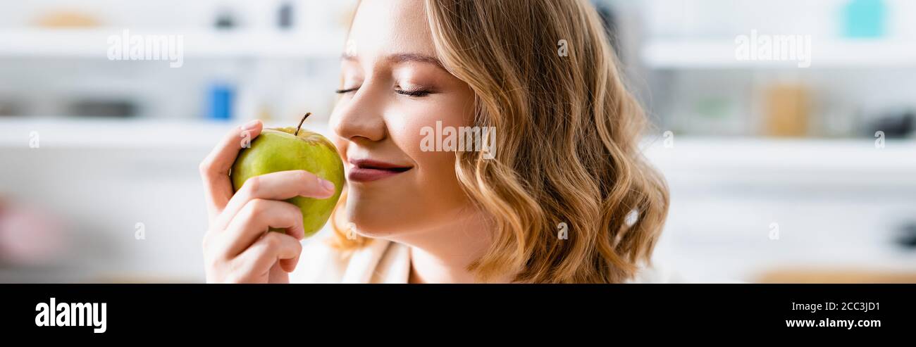 panoramic crop of woman with closed eyes smelling apple Stock Photo - Alamy