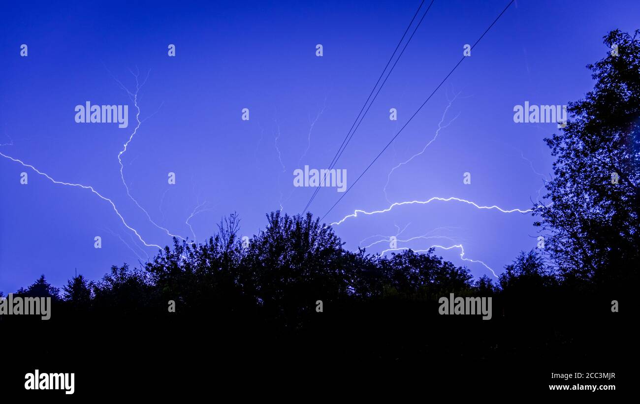 Branching lightning strikes at night over the horizon Stock Photo - Alamy