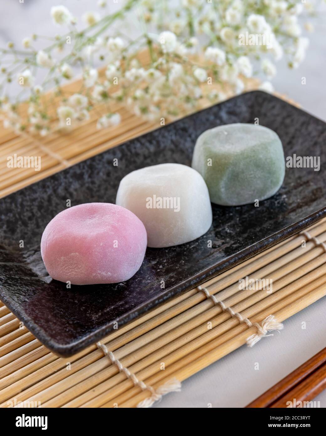 Different Flavors of Mochi on a black rectangular plate and Baby Breath ...