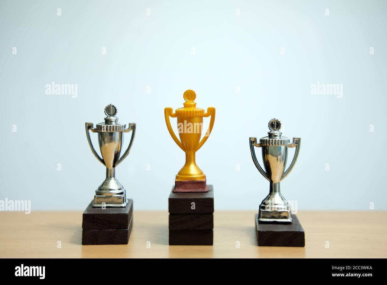 Golden trophy standing on white podium Stock Photo - Alamy