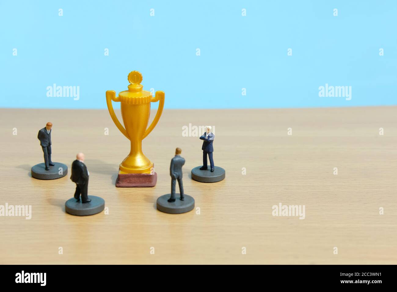 Miniature business concept - businessman lineup rank with golden trophy ...