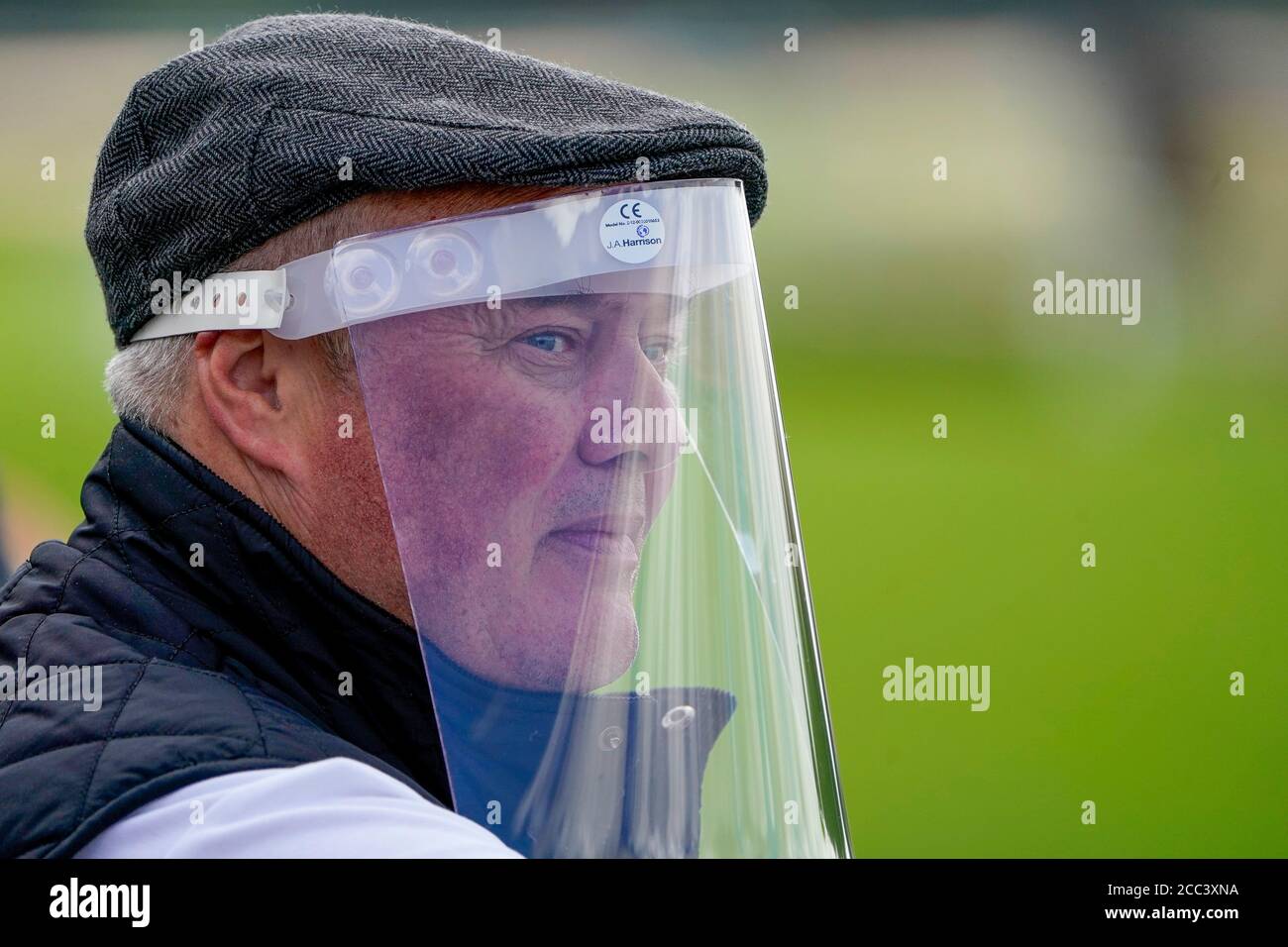 Bookmaker Steve Dunn, wears a perspex mask at Fontwell Park Racecourse ...