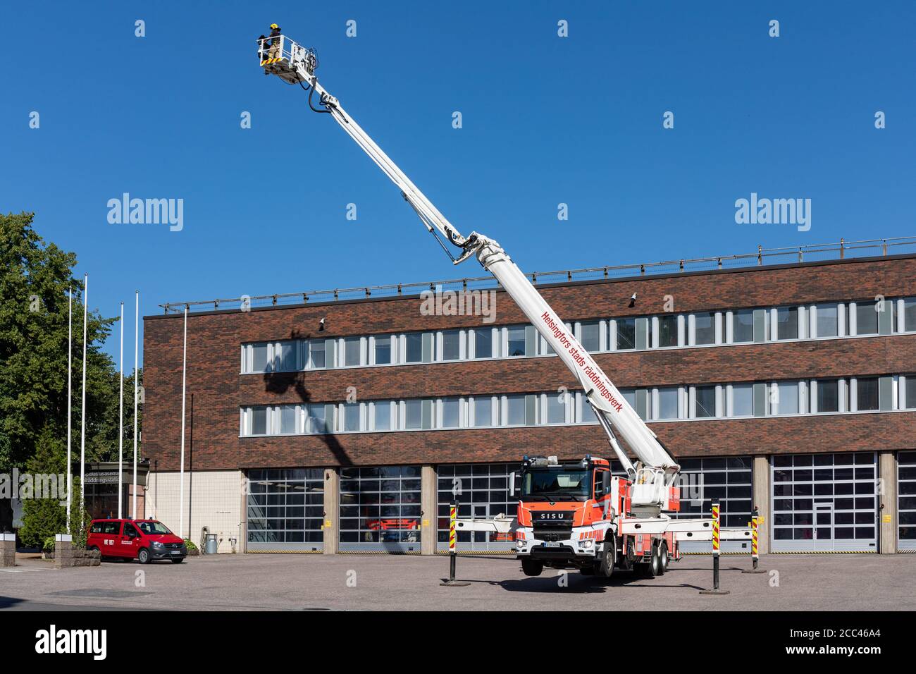 Fireman operating fire engine manlift in front of Kallio fire station ...