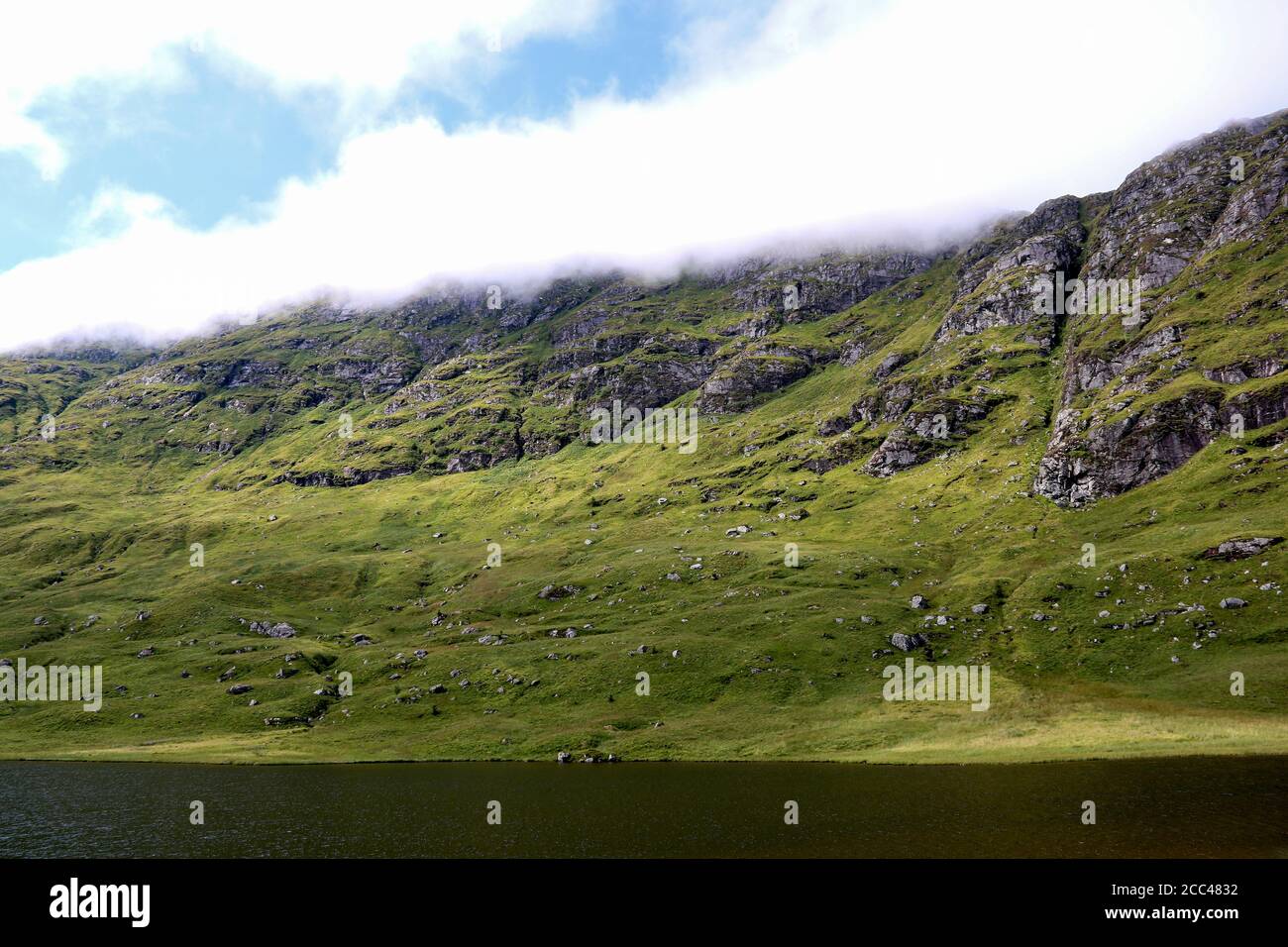 Scottish mountainside and small loch at dusk Stock Photo - Alamy