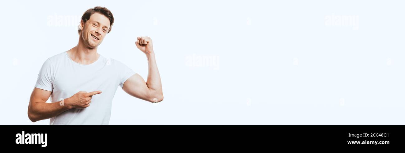 Panoramic image of man pointing with finger at muscles on arm isolated ...