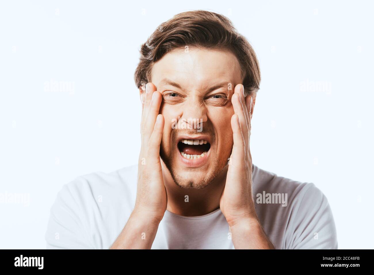 Scared man with hands near face looking at camera isolated on white ...