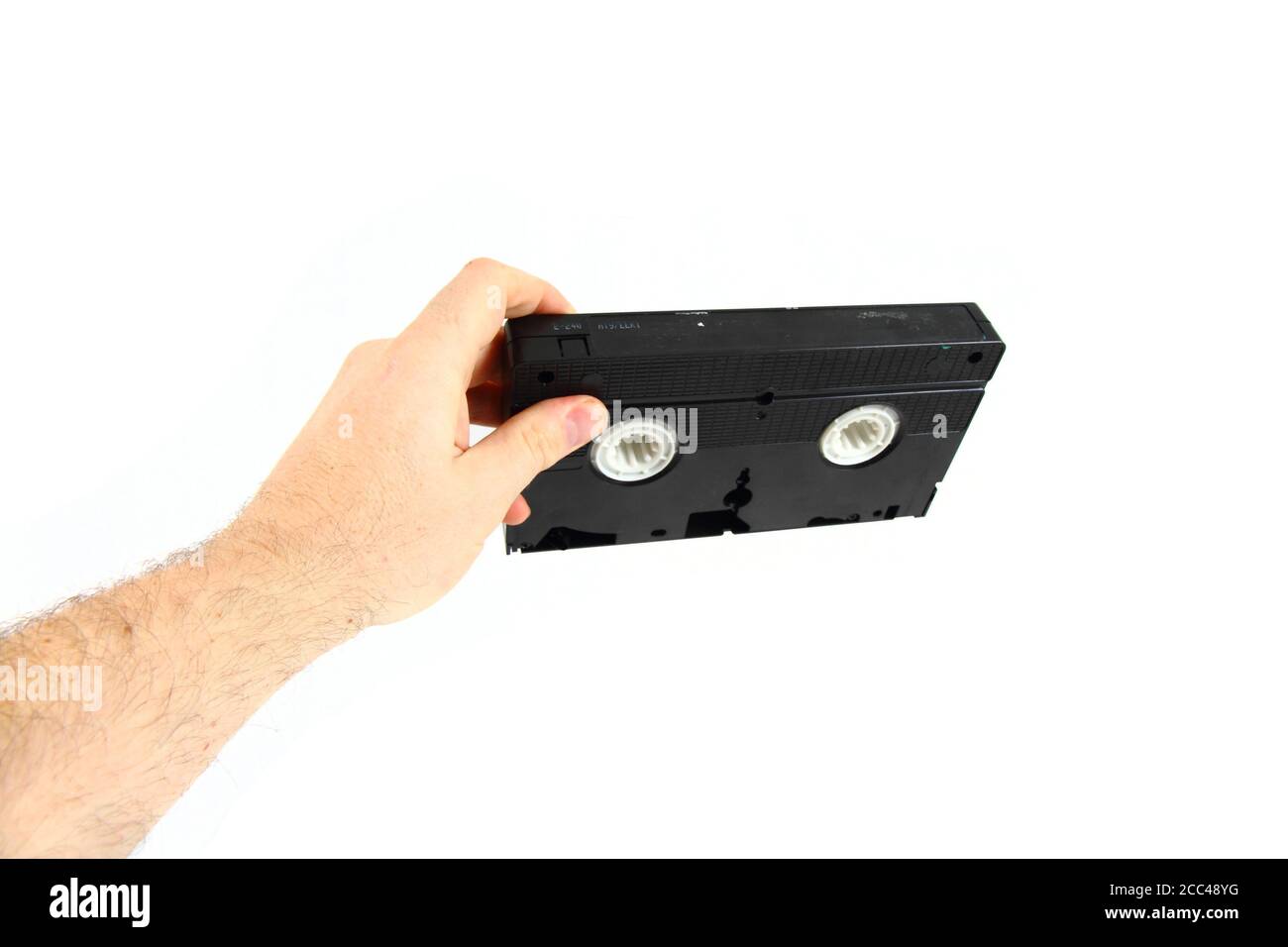 VHS video tape in the human hand isolated on the white backghround ...