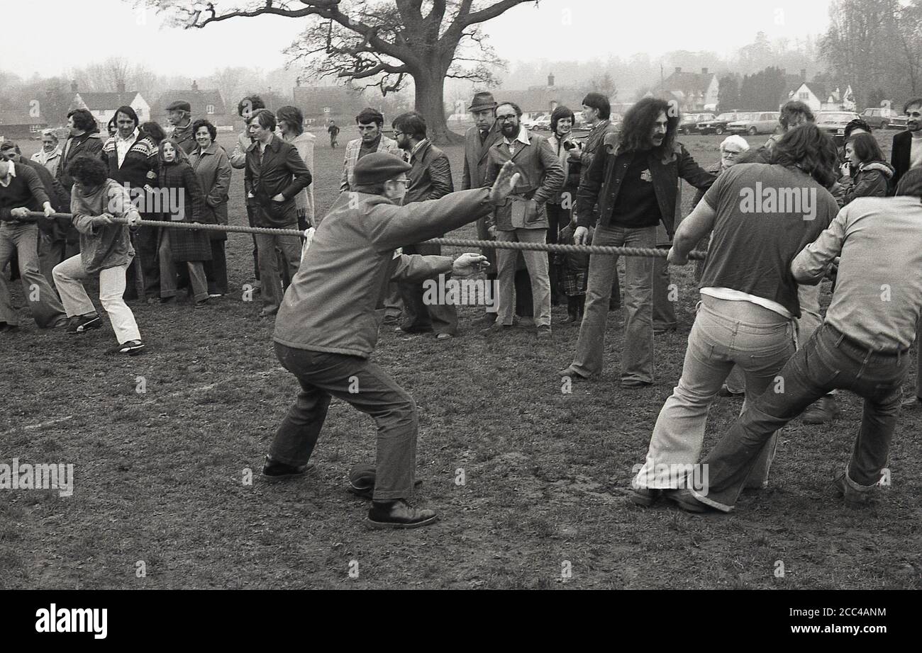 1980s, historical, spectactors watching men in jeans compete in a tug ...