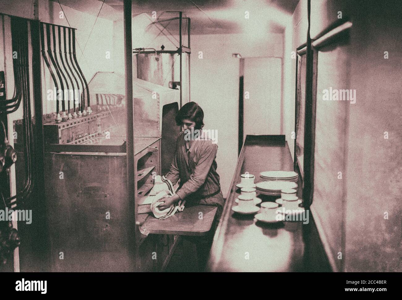 A maid prepares a dish in theHis Majesty's Airship R100’s galley. 1929 ...