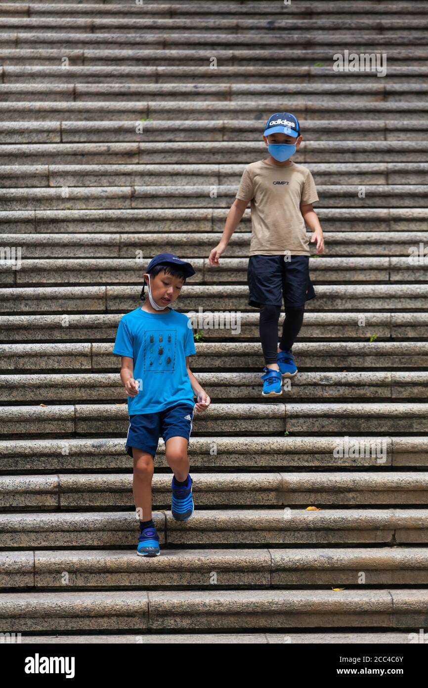 Two boys making their way down the steps carefully in outdoor location ...