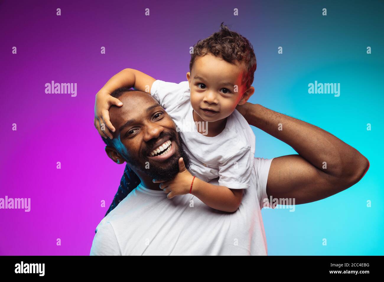African-american father and son portrait on gradient studio background ...