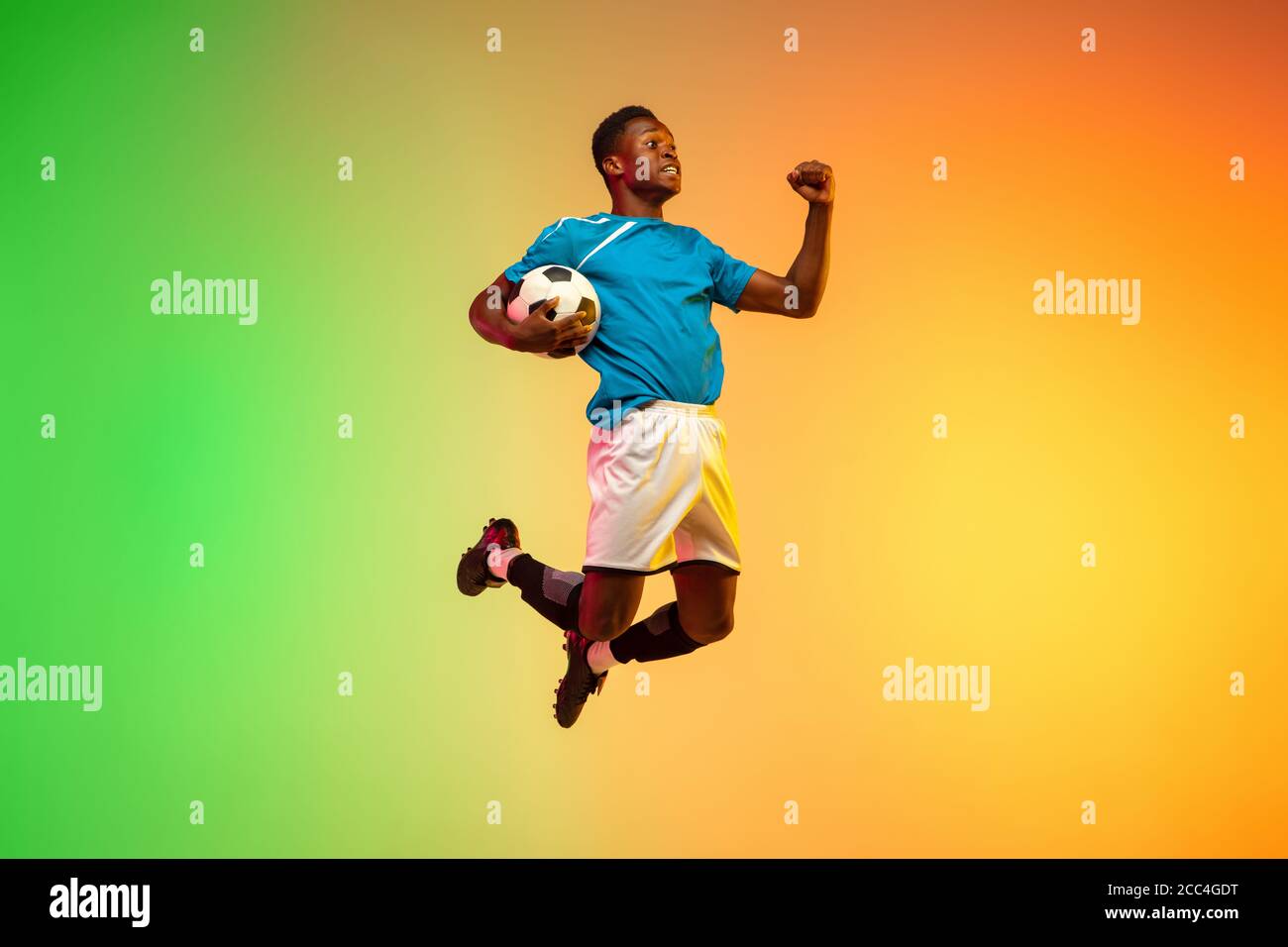 High jumping winner. Male soccer, football player training in action ...