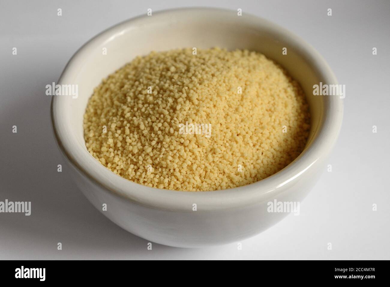Dry couscous in white ceramic bowl isolated on white Stock Photo - Alamy