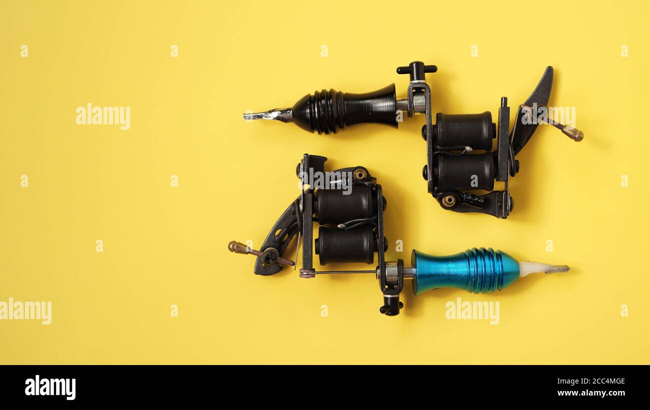 Two tattoo machines on a yellow background - tattoo industry Stock ...