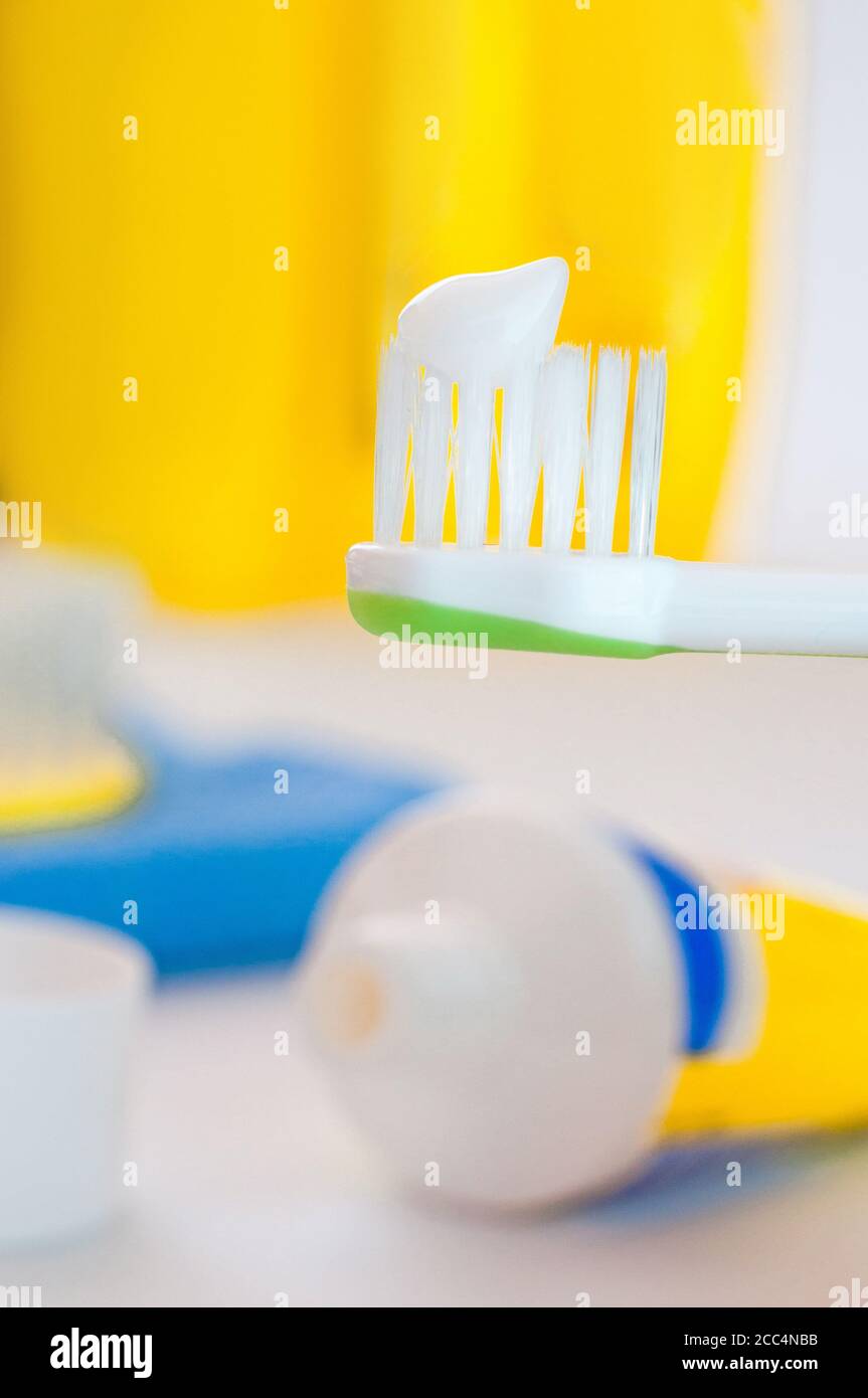 Baby first toothbrushe with toothpaste in the bathroom selective focus ...