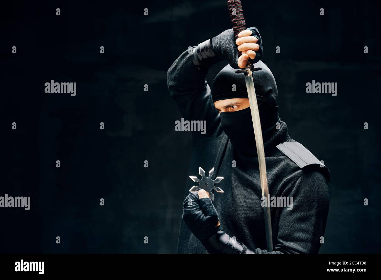 Ninja samurai warrior fighter with a sword and shuriken over black ...