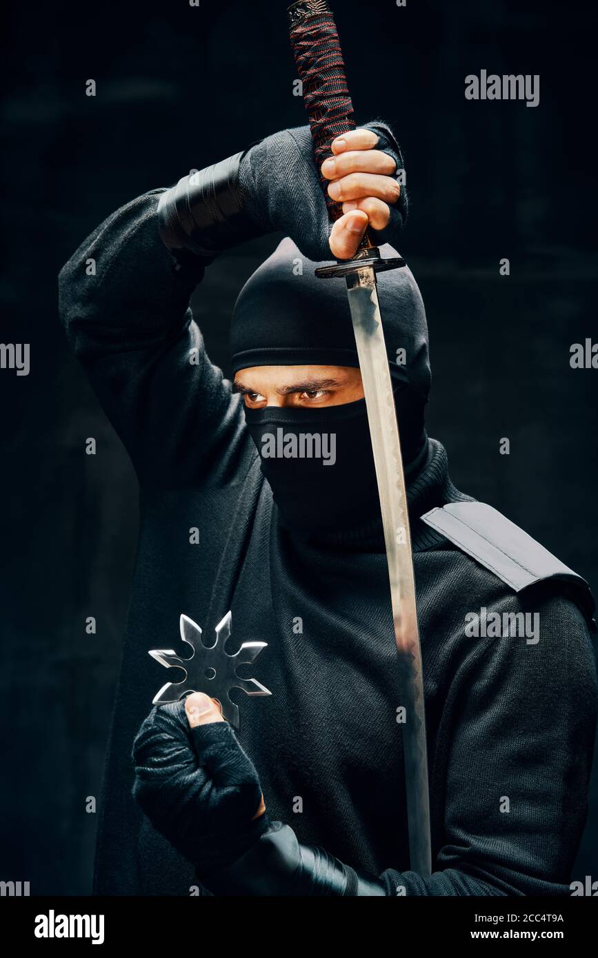 Ninja samurai warrior fighter with a sword and shuriken over black ...