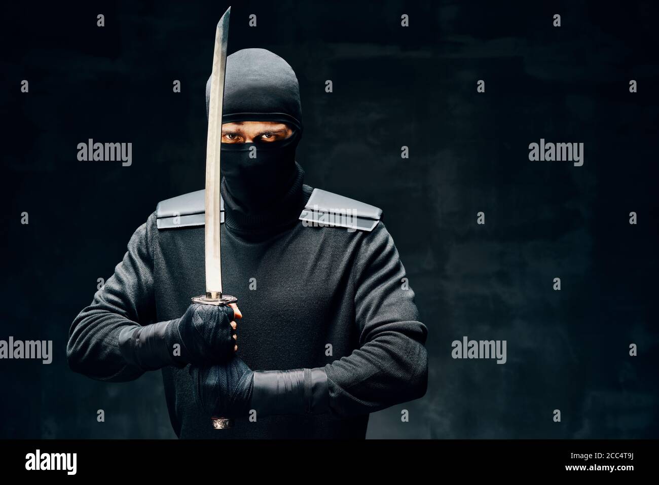 Fighting ninja posing with a sword over black background. japanese ...