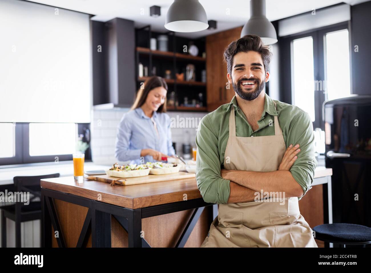Happy young friends loving couple chefs on the kitchen cooking Stock ...