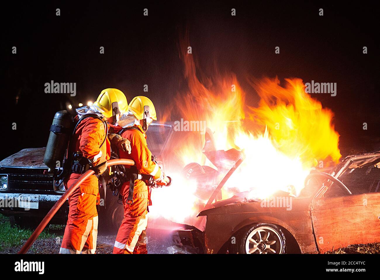 Firefighters spraying water to put out a brutal fire on the car Stock ...