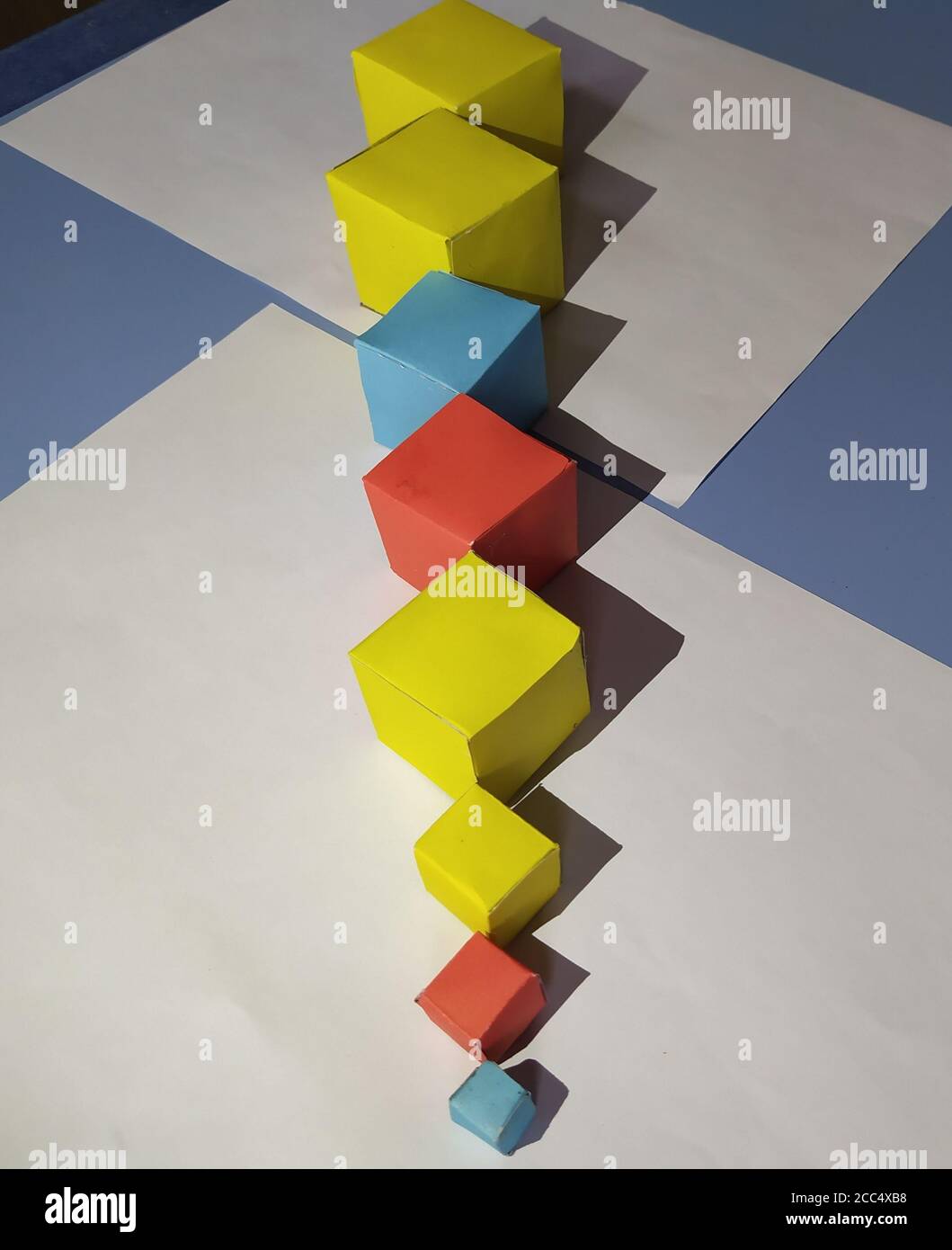 Vertical shot of colored cardboard cubes lined back Stock Photo - Alamy