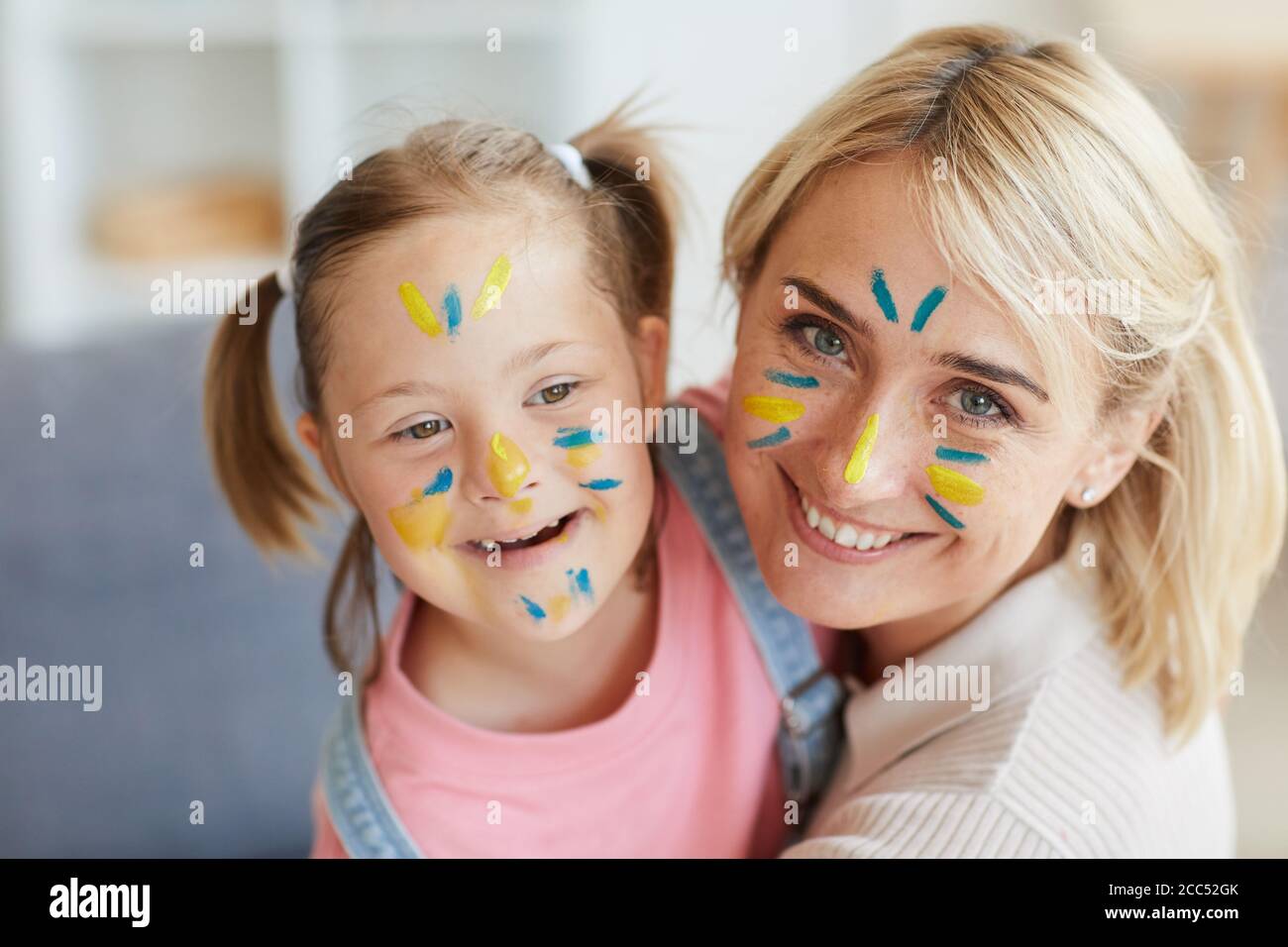 Portrait of happy mother and her daughter with down syndrome with ...