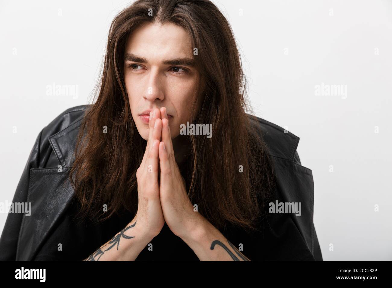 Portrait of handsome thinking man with long hair wearing lather jacket ...