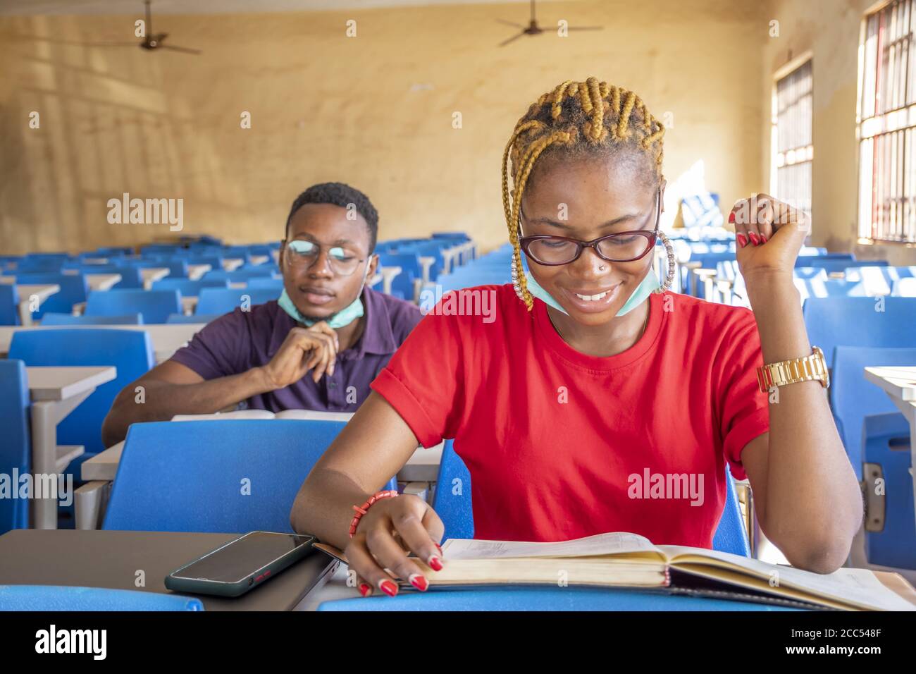 Shallow focus of two young African students wearing facemasks and ...