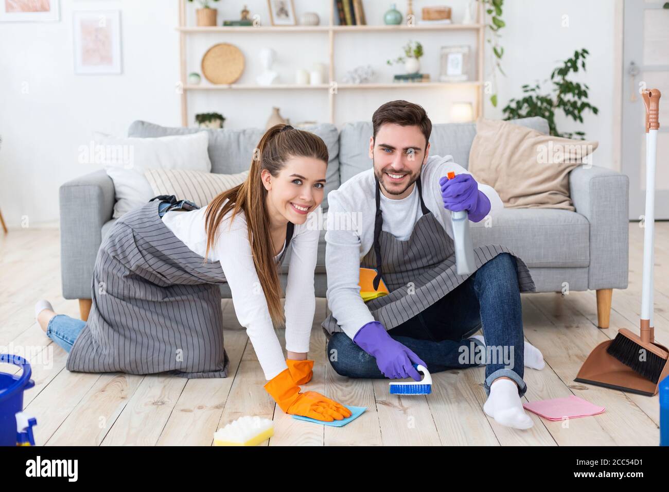 Easy cleaning with pleasure. Happy man and woman wash floor with ...