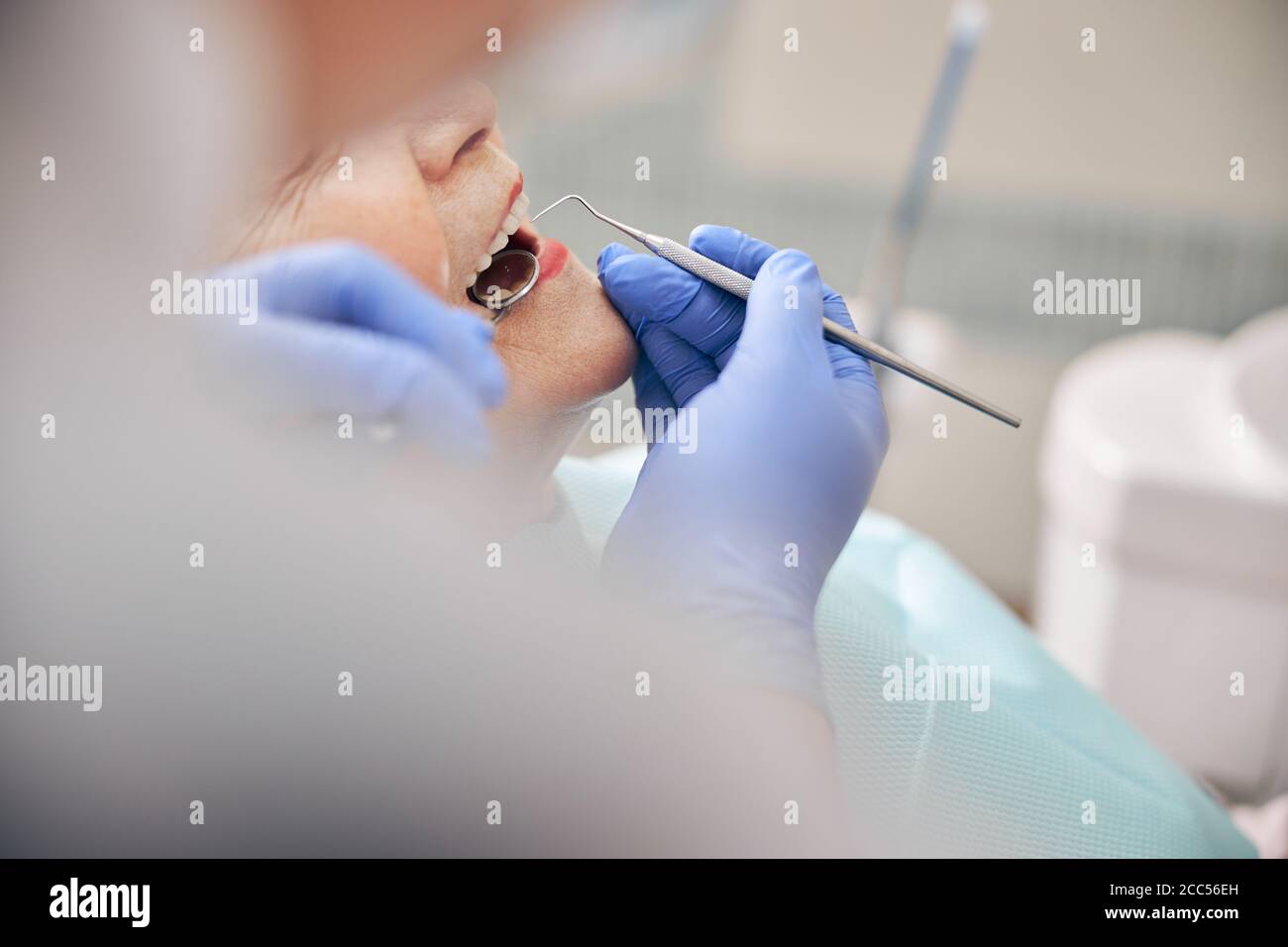 Dentist examining a patient teeth with dental tools Stock Photo - Alamy
