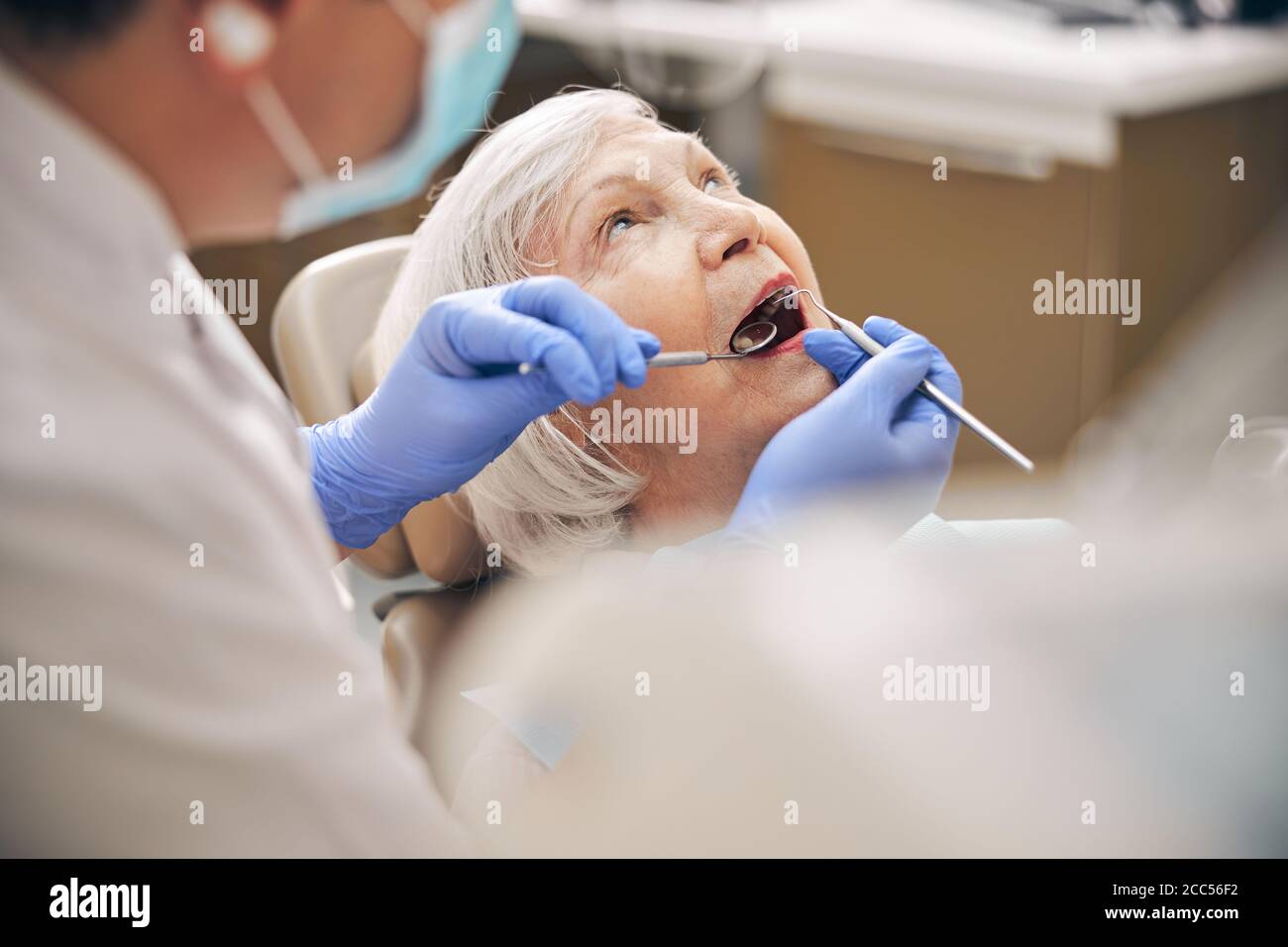 Elderly female having her teeth examining in the orthodontist Stock ...