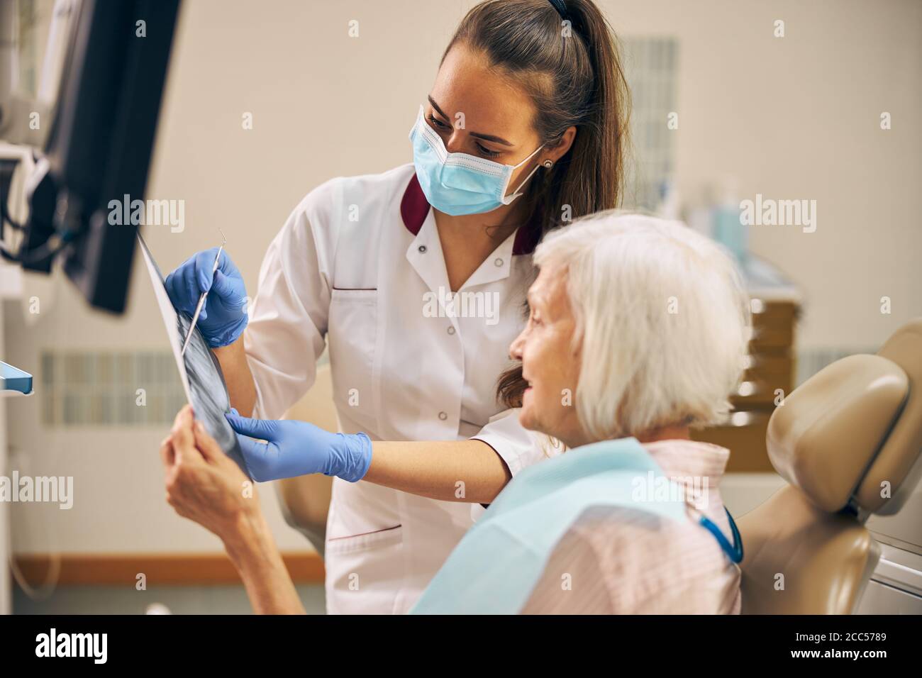 Beautiful woman checking teeth after curing teeth in dental clinic ...
