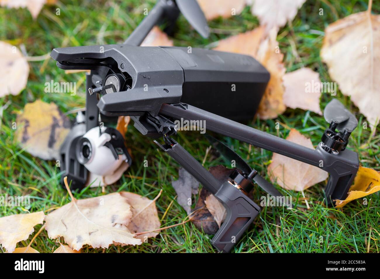 Broken black quadcopter drone uav lying on green grass lawn on ground ...