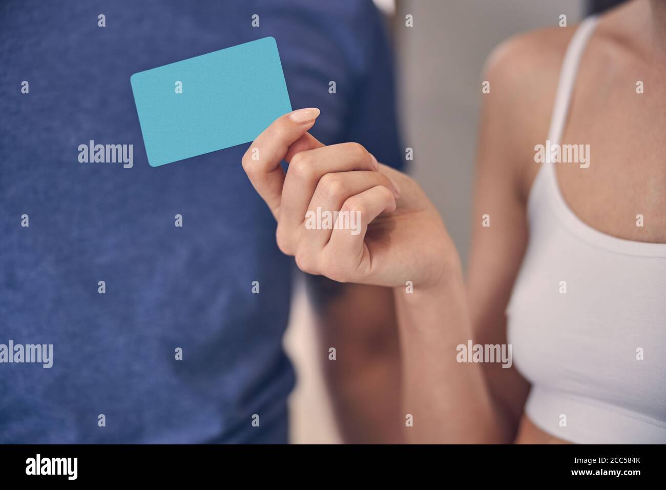 Thin hand of female holding blue card Stock Photo - Alamy