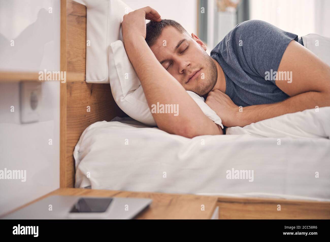 Attractive young man relaxing in bed at home Stock Photo - Alamy
