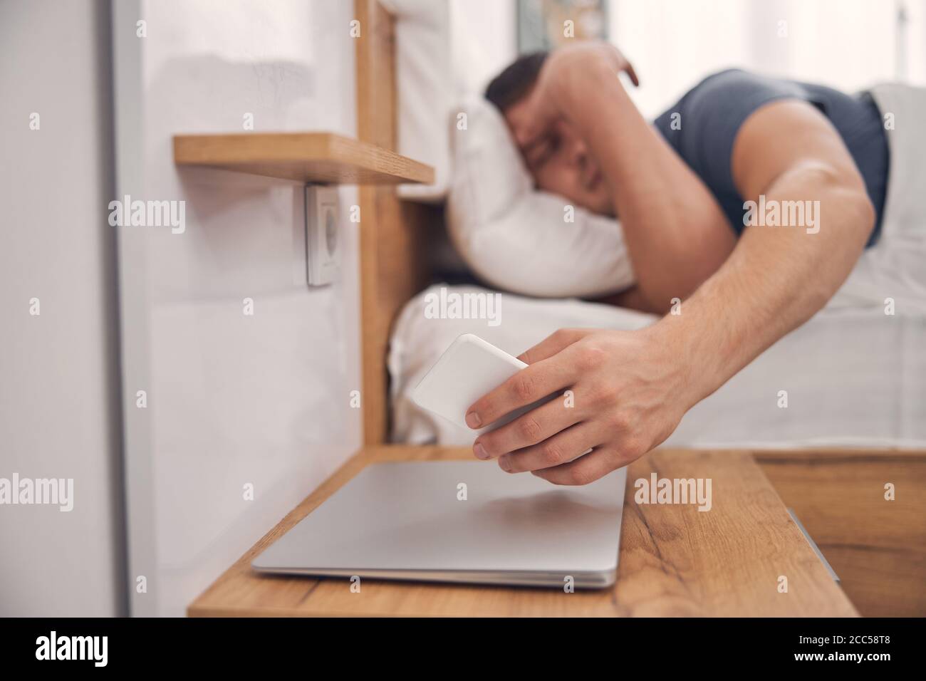 Young man spending time in bedroom alone Stock Photo - Alamy