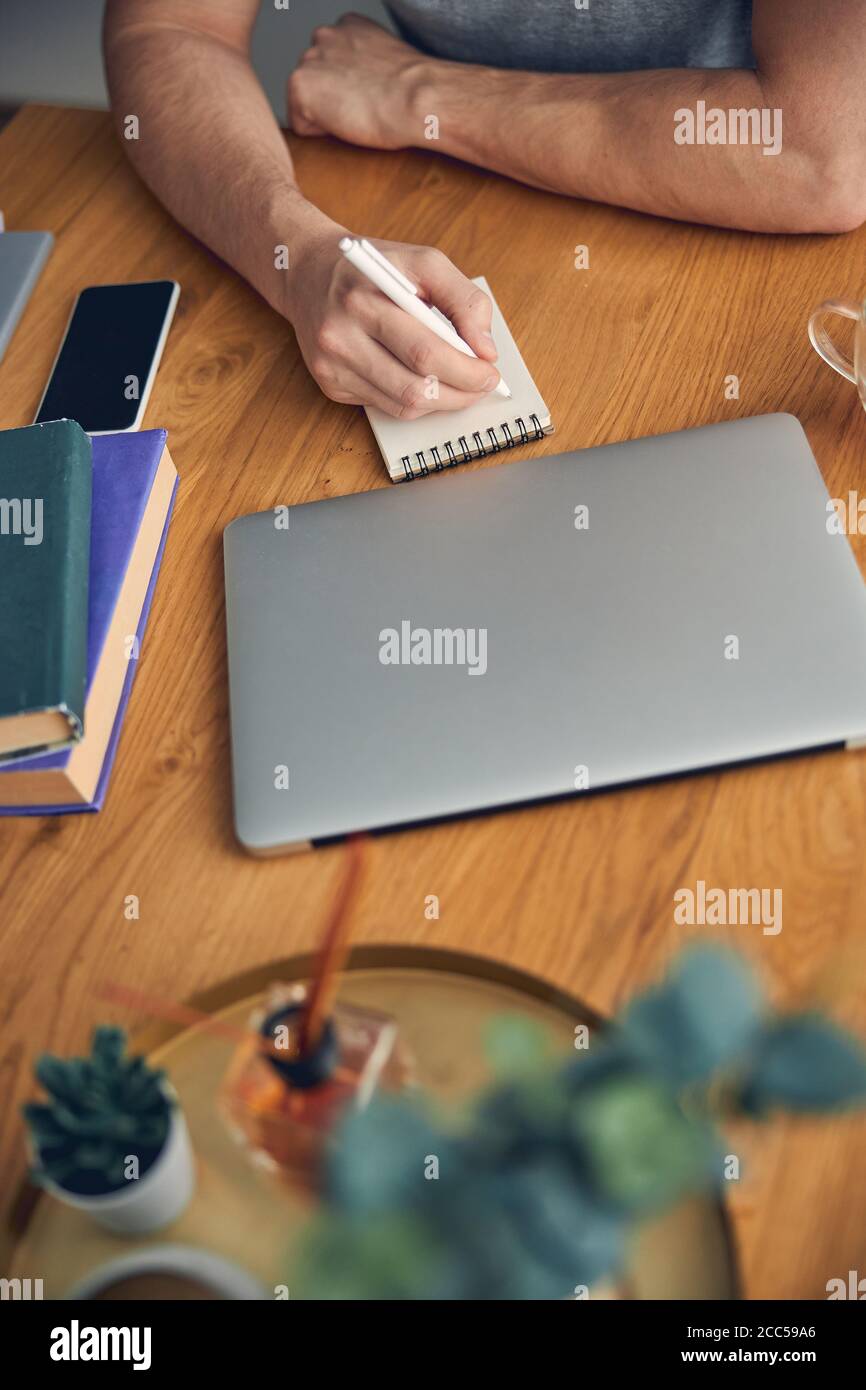 Man writing in small notebook with pen Stock Photo - Alamy
