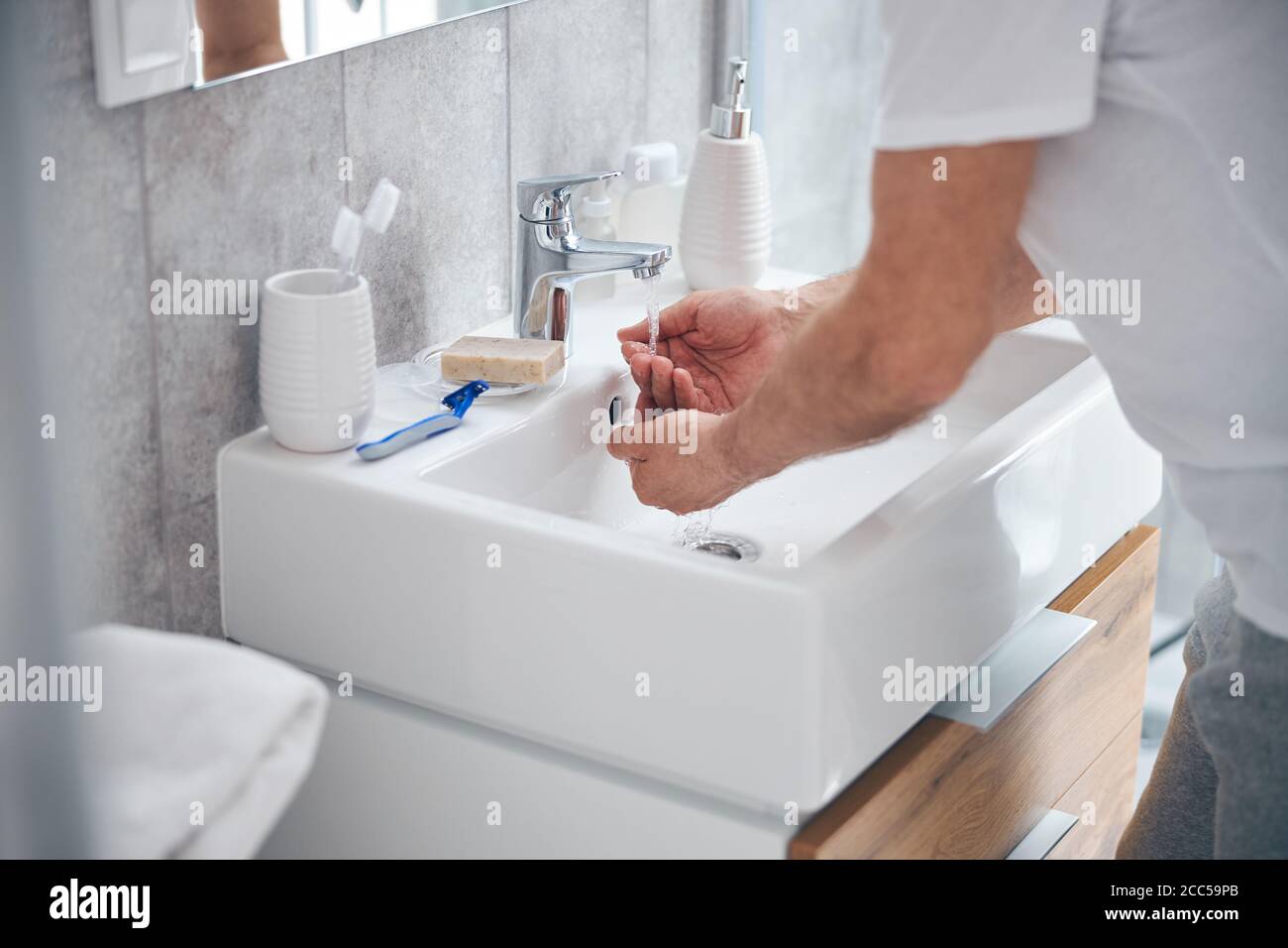 Male standing in front of the sink Stock Photo - Alamy