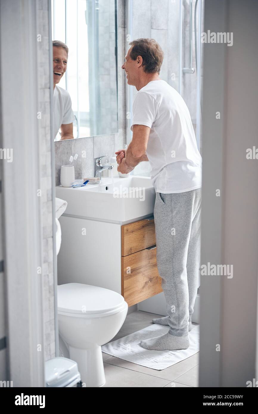 Cheerful Caucasian male standing in a bathroom Stock Photo - Alamy